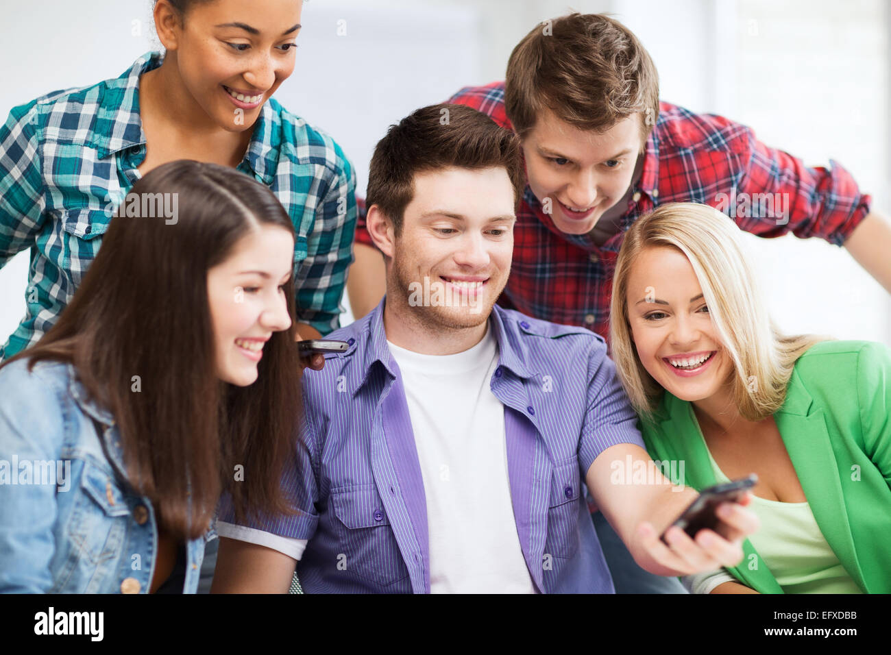 students looking into smartphone at school Stock Photo - Alamy