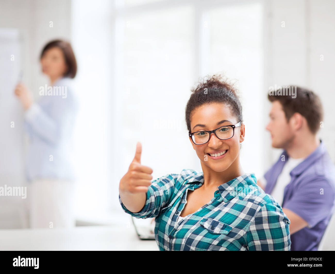 african student girl showing thumbs up Stock Photo - Alamy