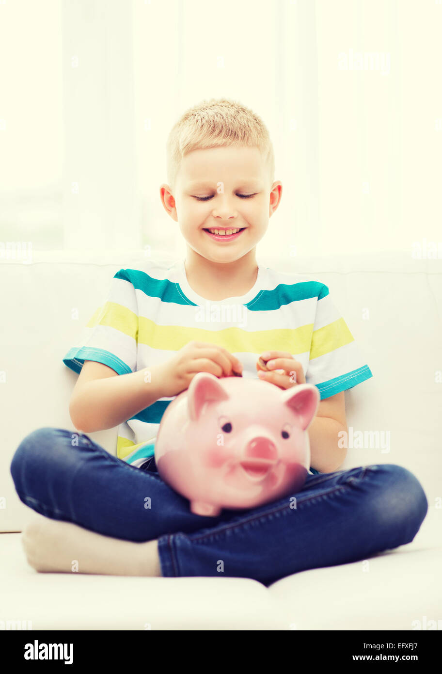 smiling little boy with piggy bank at home Stock Photo - Alamy