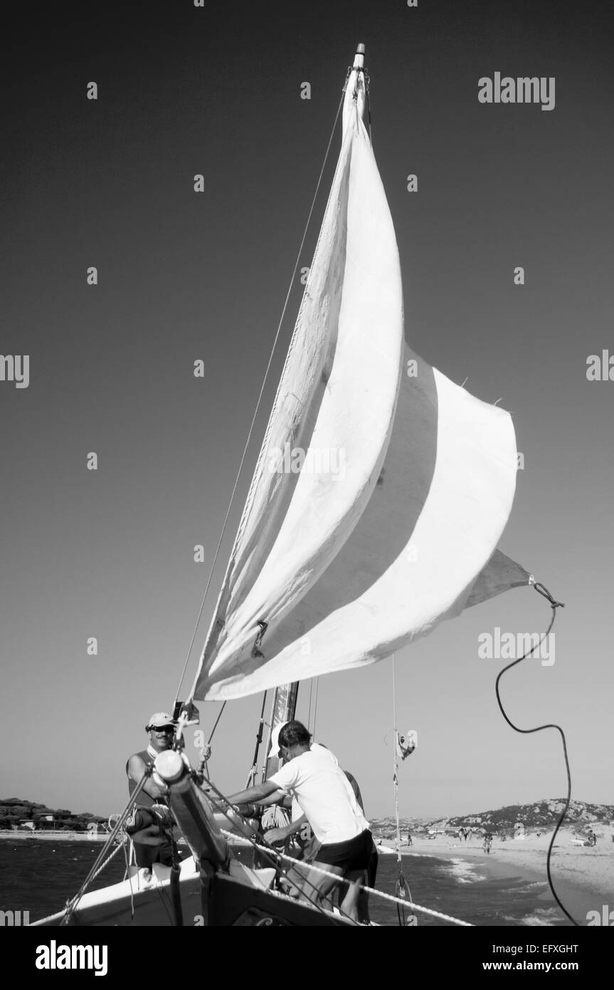 Lateen (Latin) sail boat and crew on the sea near the coast of Palau ...
