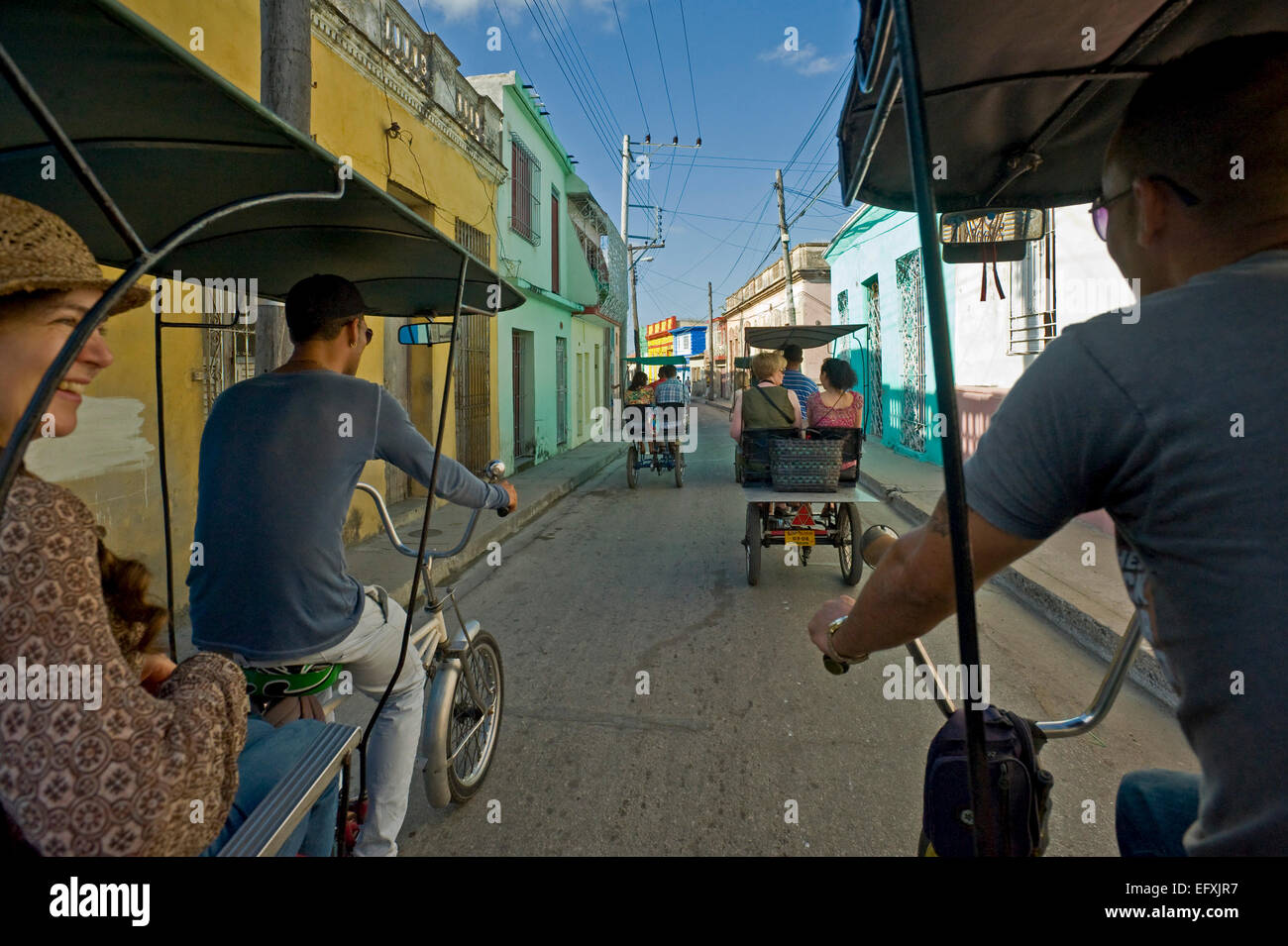 Horizontal view of bicitaxis riding through the streets in Camaguey ...