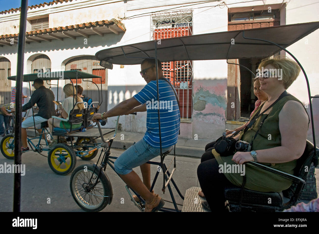 Horizontal view of bicitaxis riding through the streets in Camaguey ...