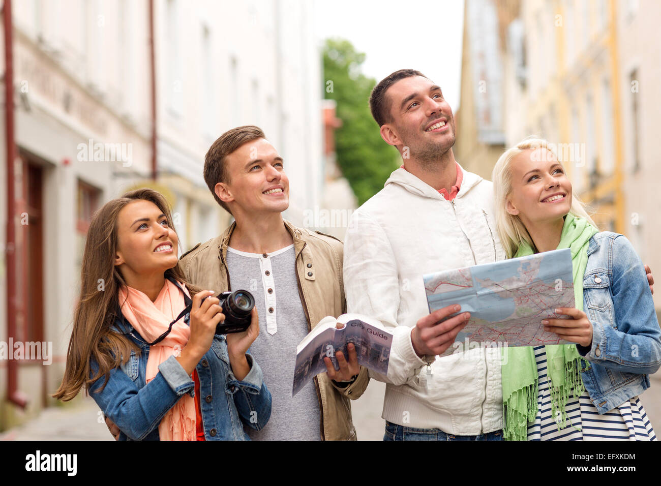 group of friends with city guide, map and camera Stock Photo - Alamy