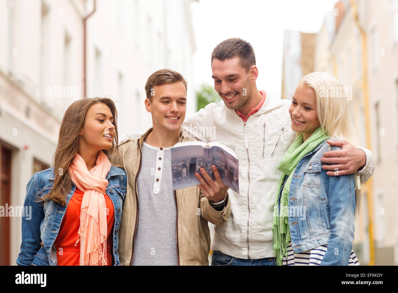 group of friends with city guide exploring town Stock Photo - Alamy