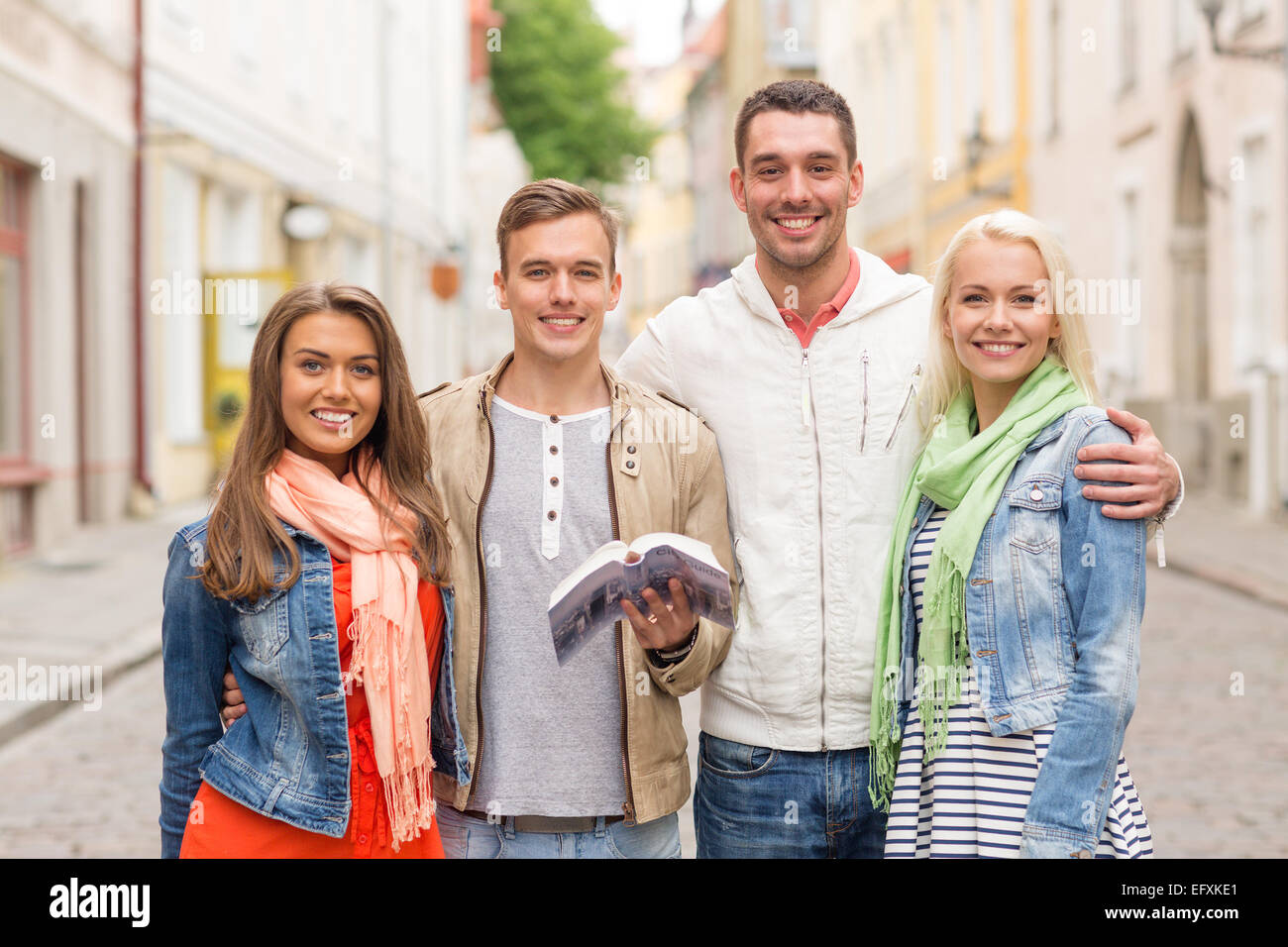 group of friends with city guide exploring town Stock Photo - Alamy