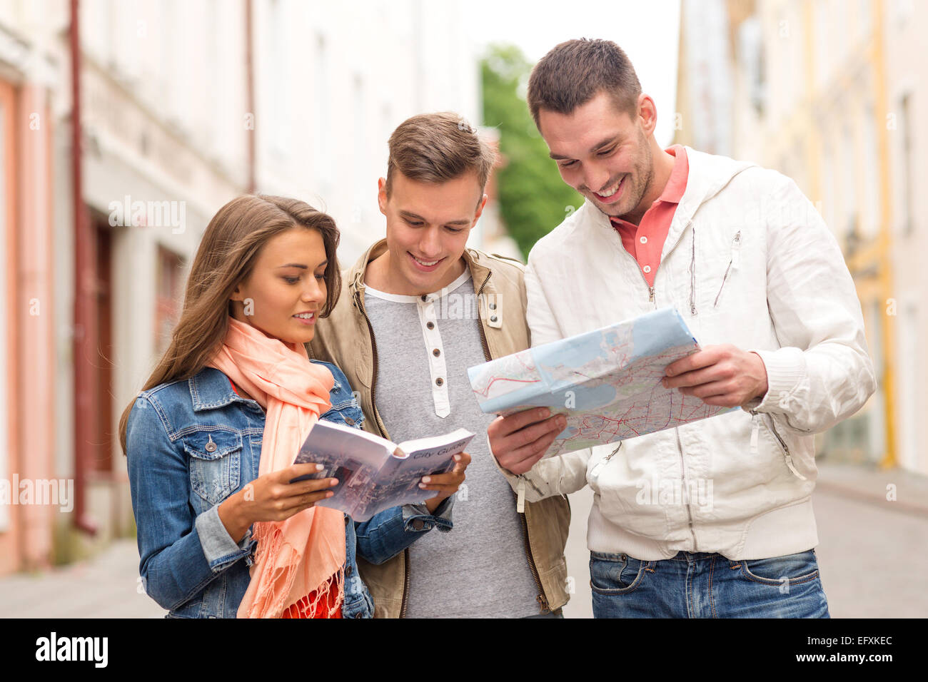 group of smiling friends with city guide and map Stock Photo - Alamy