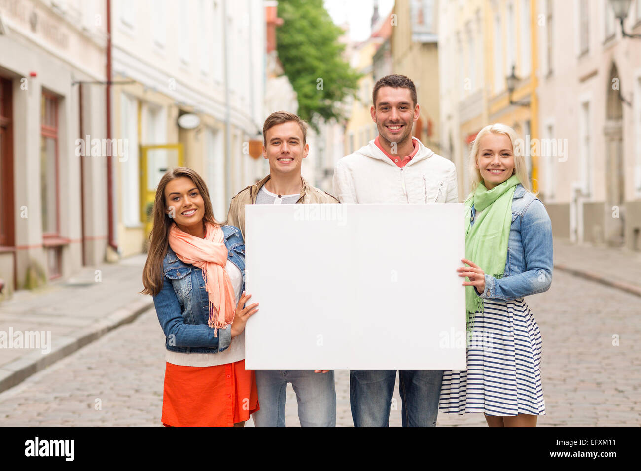 group of smiling friends with blank white board Stock Photo - Alamy