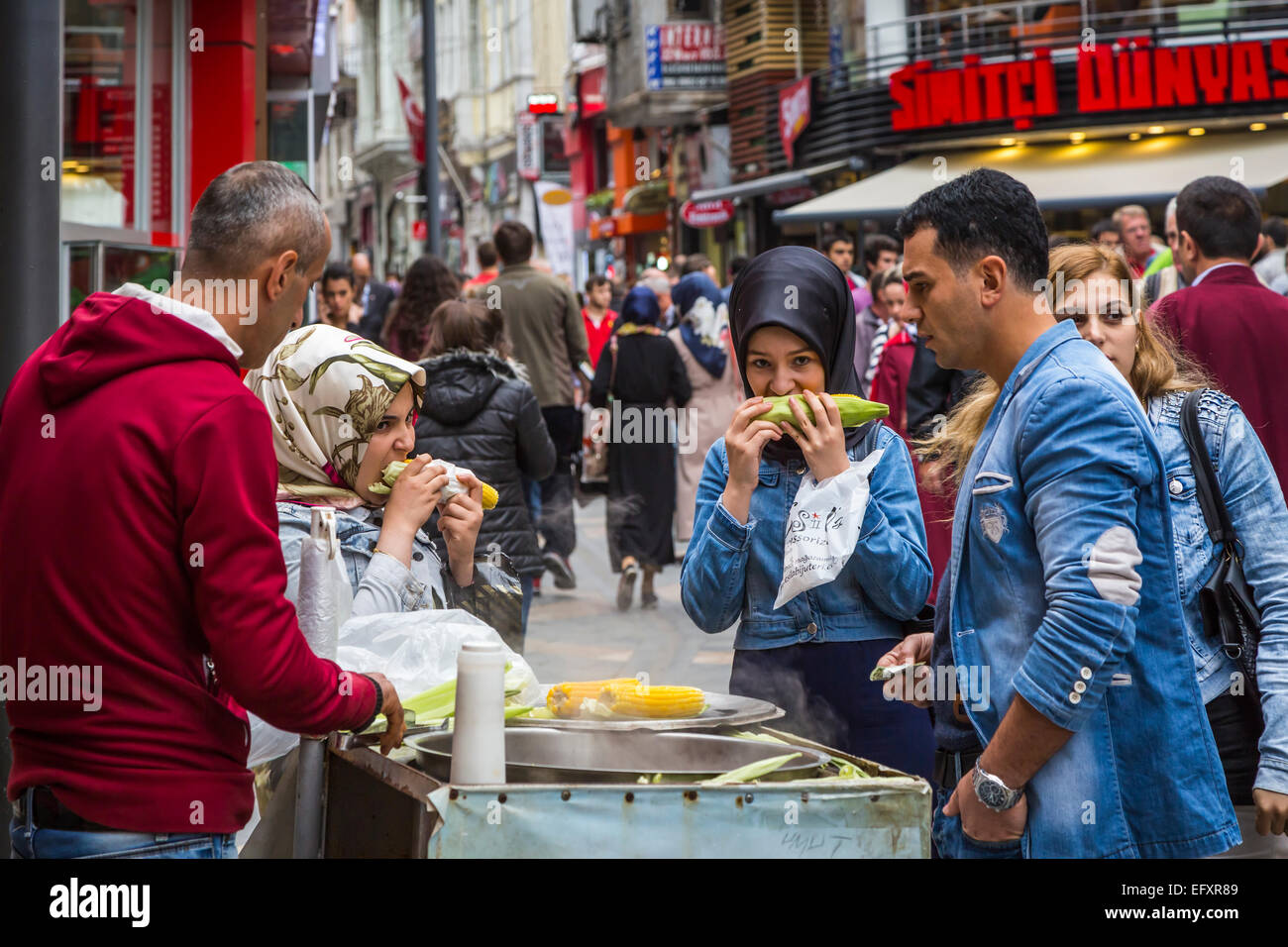 People eating corn at a roasted corn kiosk on the street in Trabzon ...