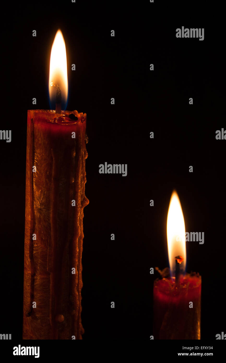 two lit candles in a dark room, tall and short difference Stock Photo ...