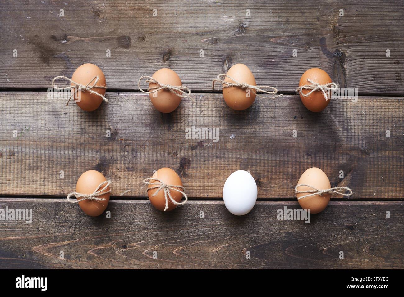 Two rows of eggs tied by threads on wooden background Stock Photo - Alamy