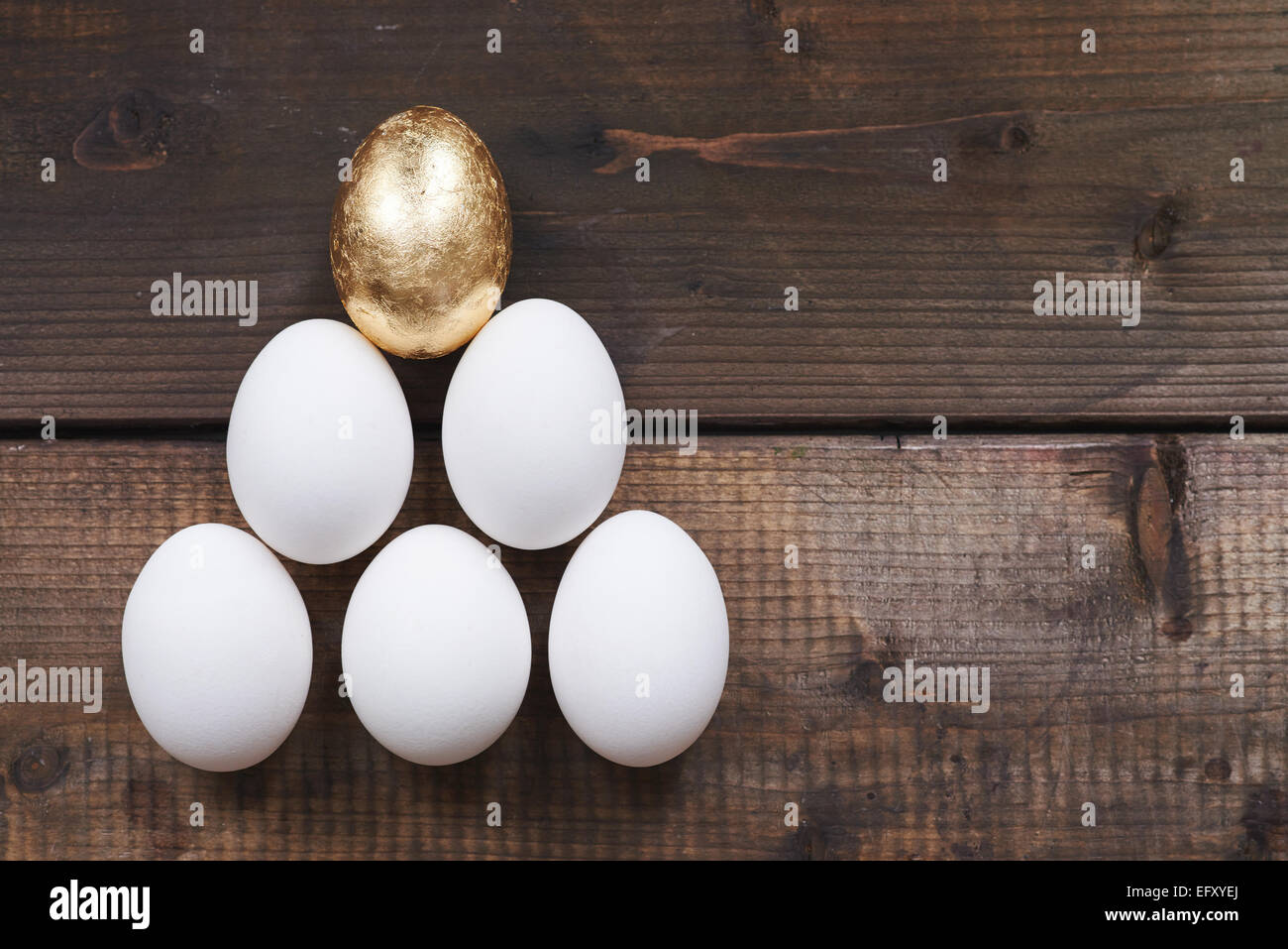 Pyramid made up of eggs with golden one on its top Stock Photo - Alamy