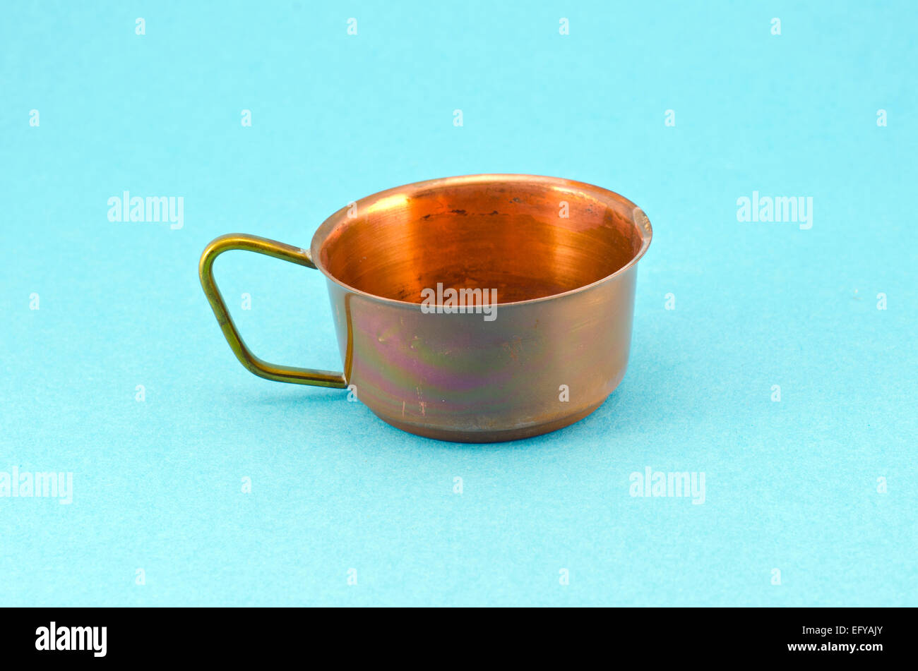 old antique brass metal cup on blue background Stock Photo - Alamy