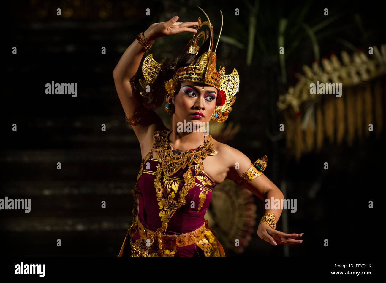 Young woman performing a traditional Balinese dance on stage in Ubud ...