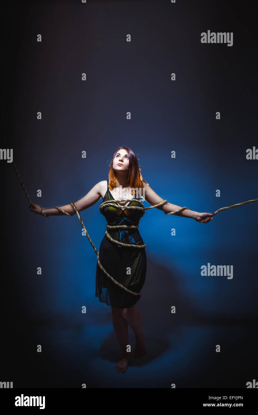 girl of European appearance in dress hands tied with rope on a g Stock ...