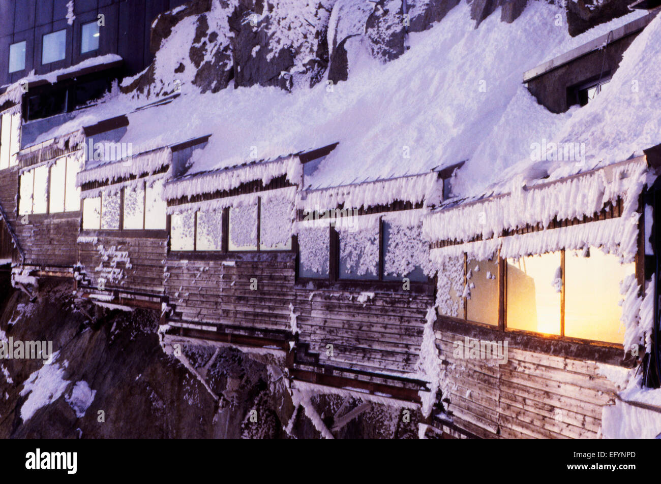 sunset colours warm up the windows covered in winter ice at the ...