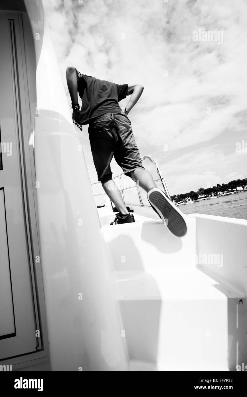 guy on a boat running Stock Photo - Alamy