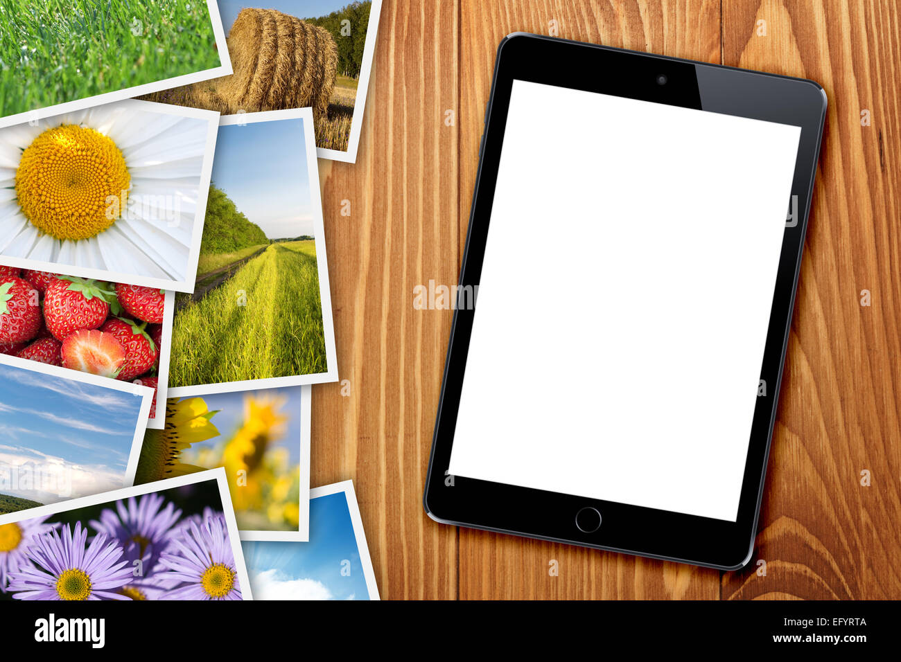 Tablet with blank screen and stack of printed pictures collage on ...