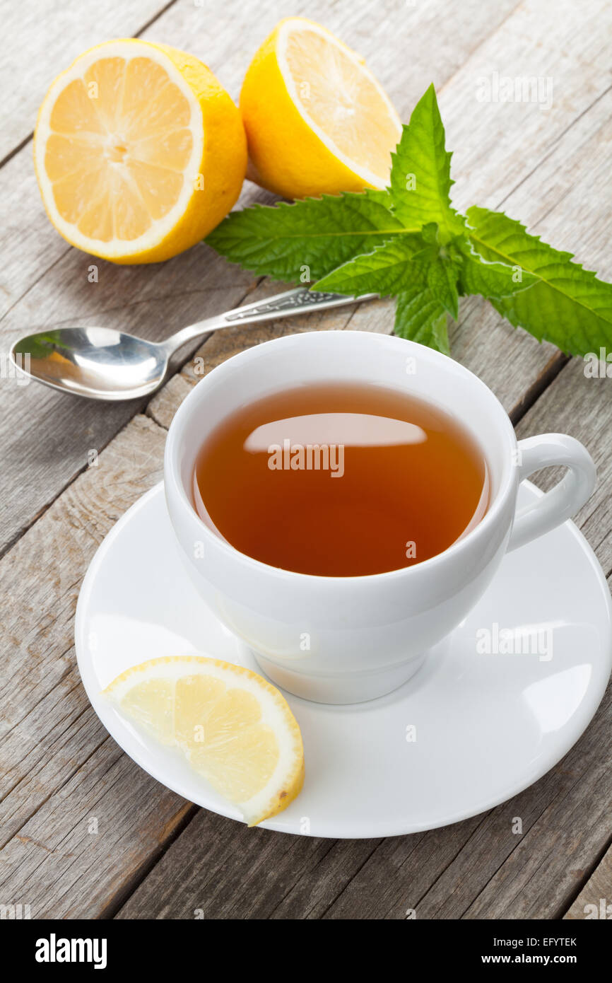 Green tea with lemon and mint on wooden table background Stock Photo ...