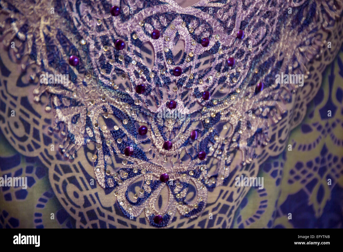 Rhinestones and beads on purple fabric background Stock Photo - Alamy