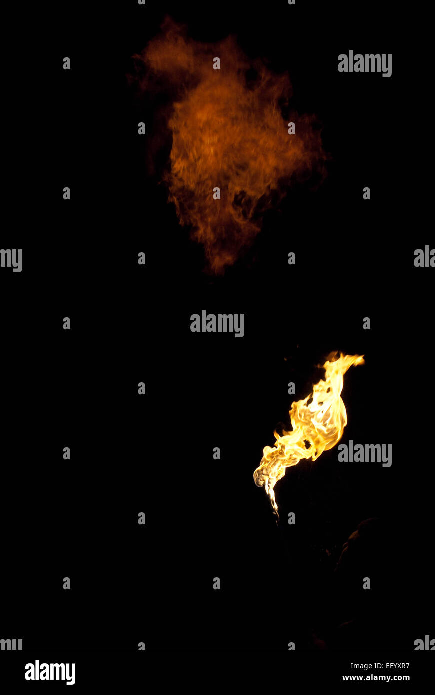 fire-eater performance on a street and audience on a dark background ...