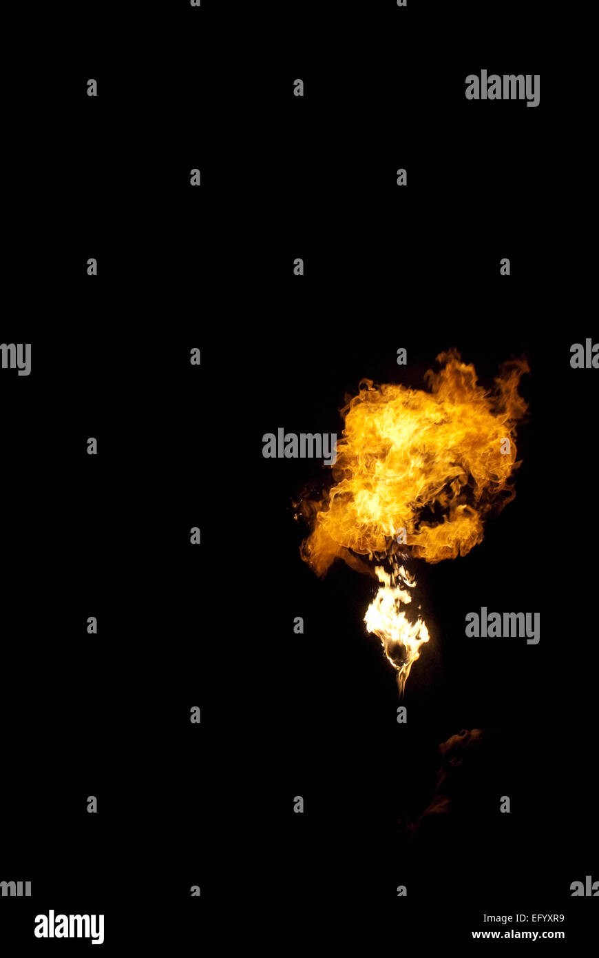 fire-eater performance on a street and audience on a dark background ...