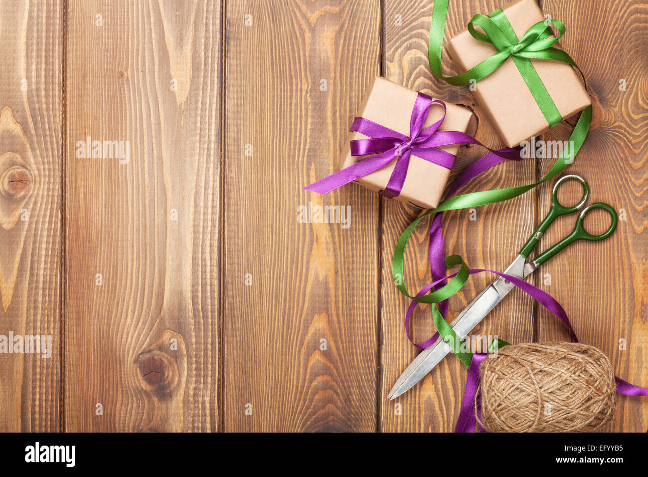 Gift wrapping with boxes and scissors over wooden table with copy space ...