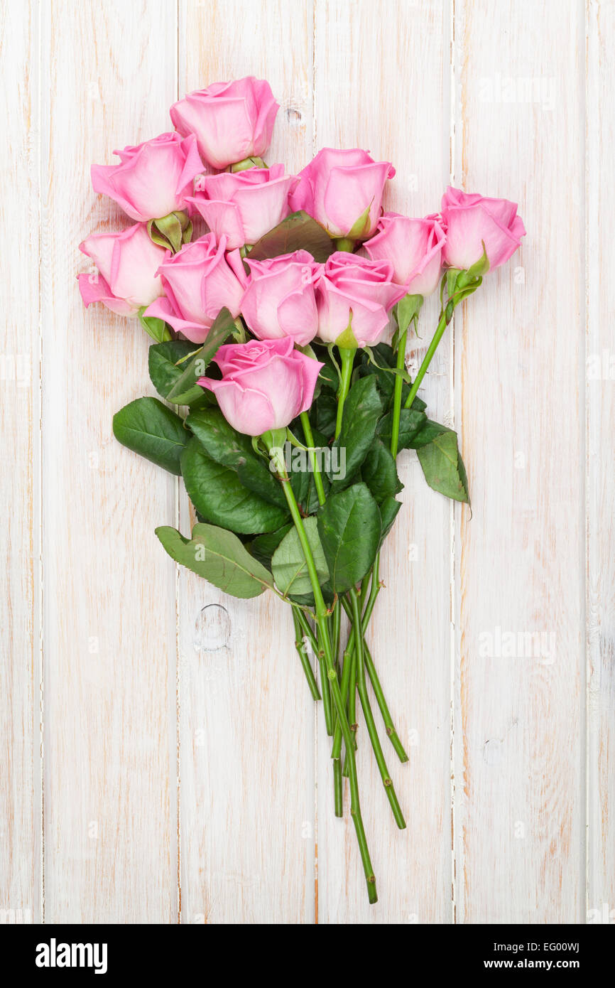 Pink roses bouquet over white wooden table. Top view Stock Photo - Alamy