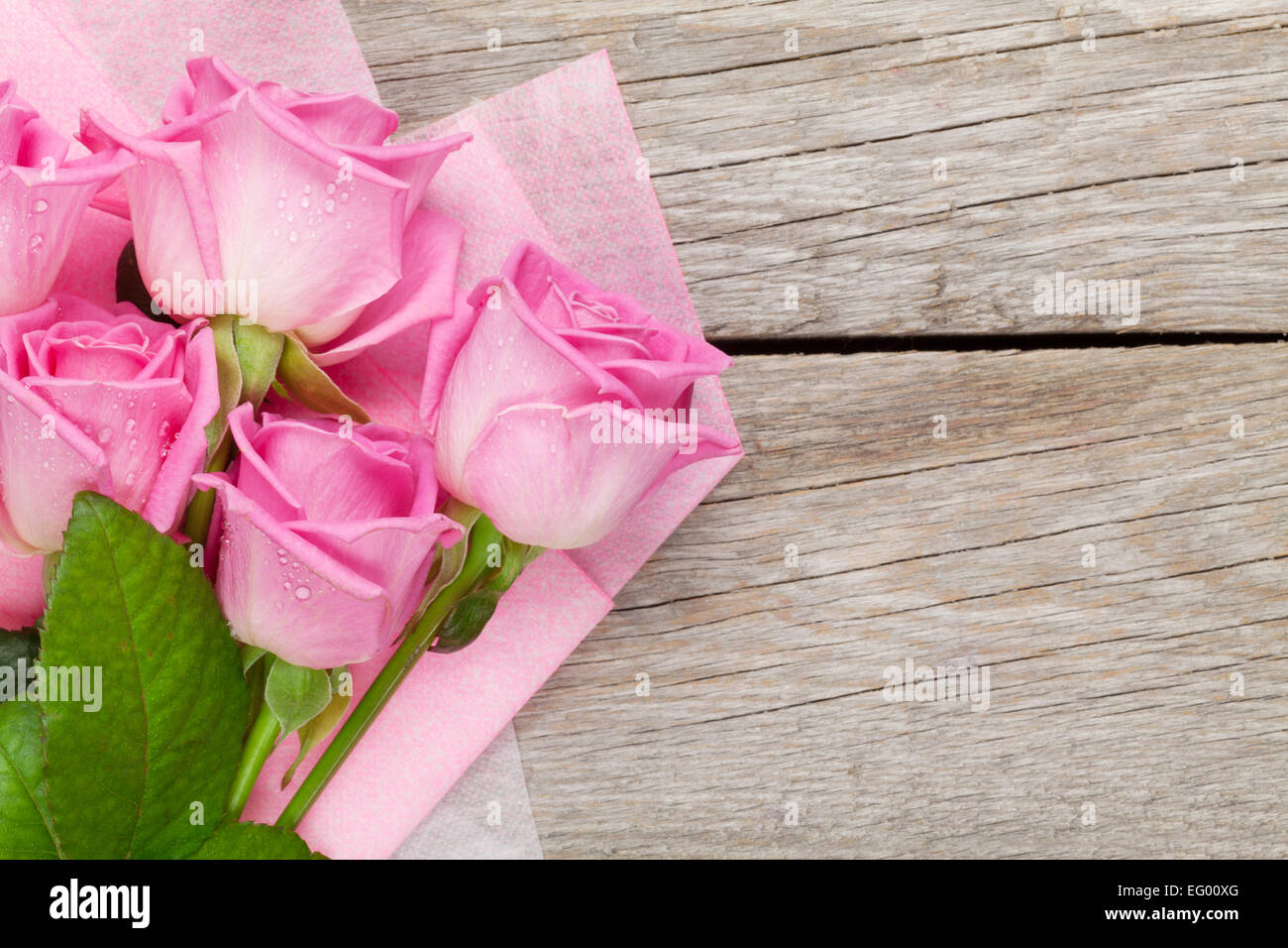 Garden pink roses bouquet over wooden table. Top view with copy space ...