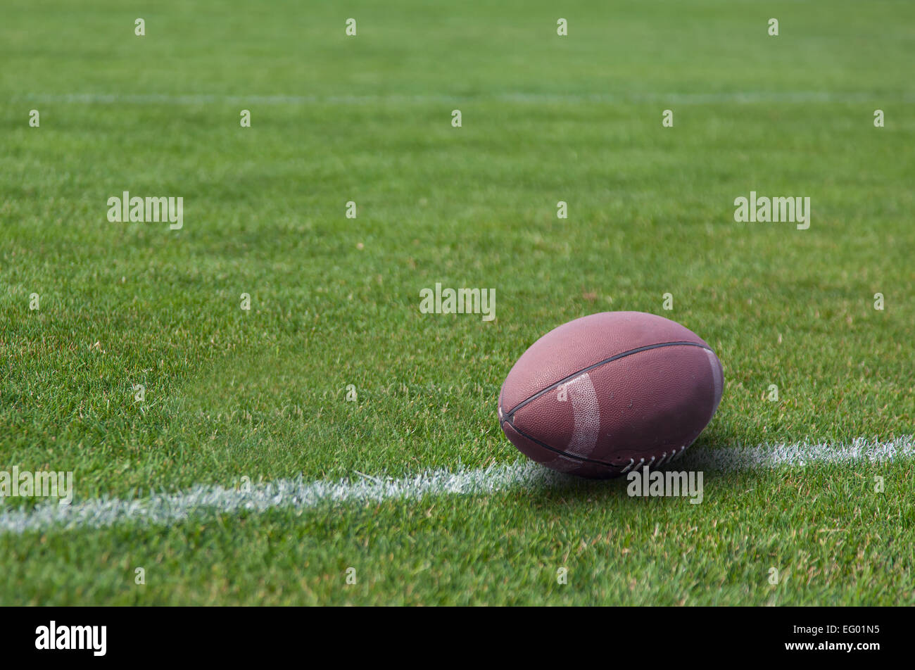 American rugby ball on the grass in the stadium Stock Photo - Alamy