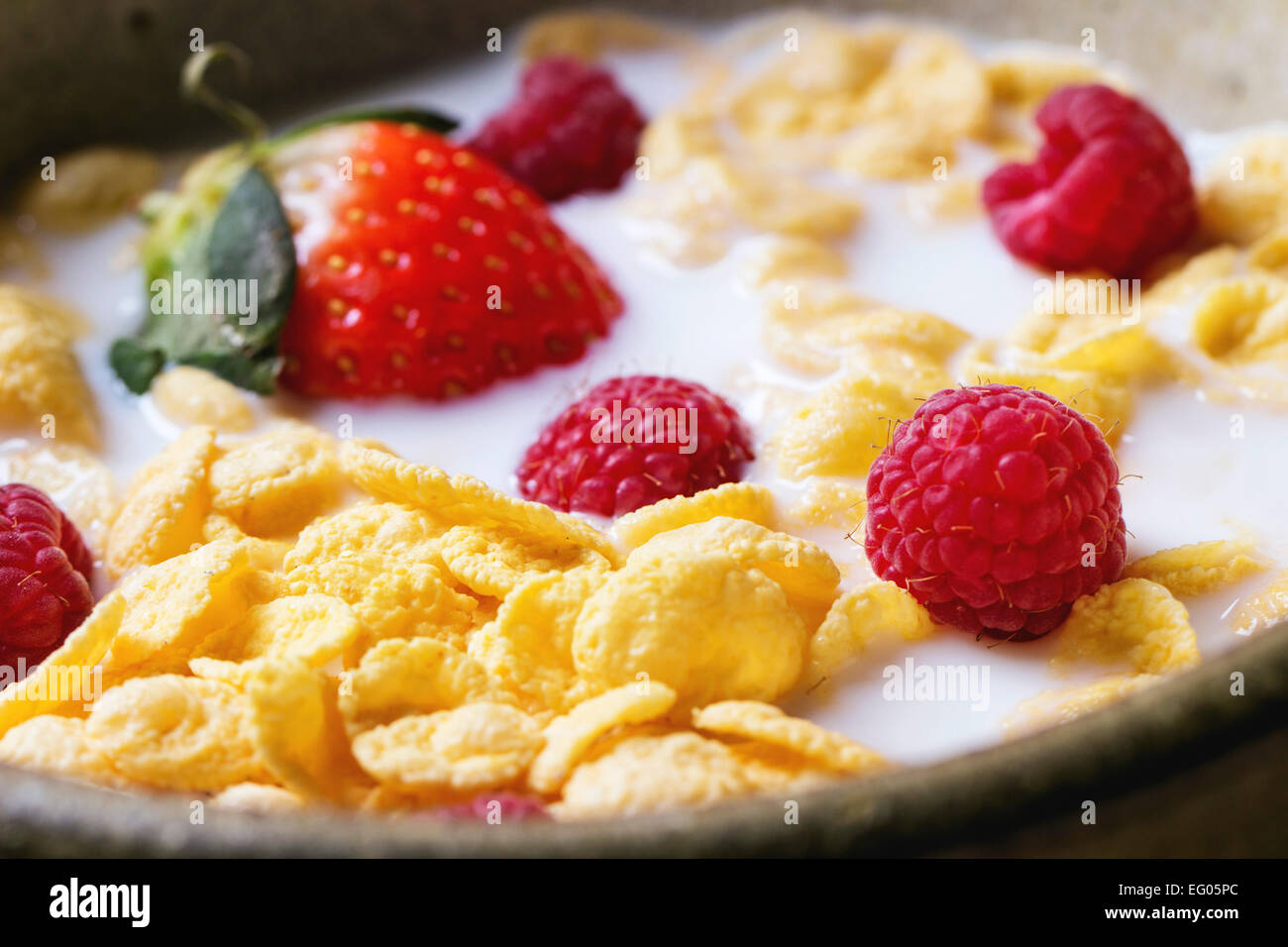 Cornflakes with milk and berries in ceramic bowl Stock Photo - Alamy