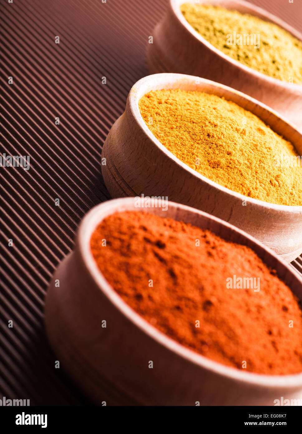 spices hops-suneli,turmeric,paprika in a wooden bowl on a brown ...