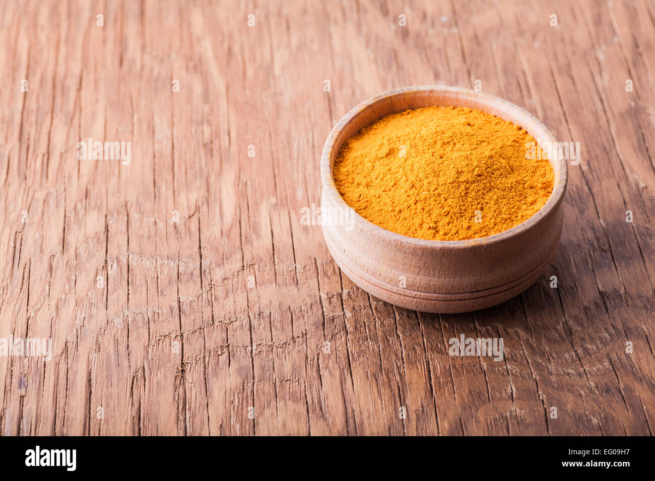 spice turmeric in a wooden bowl on a vintage background Stock Photo - Alamy