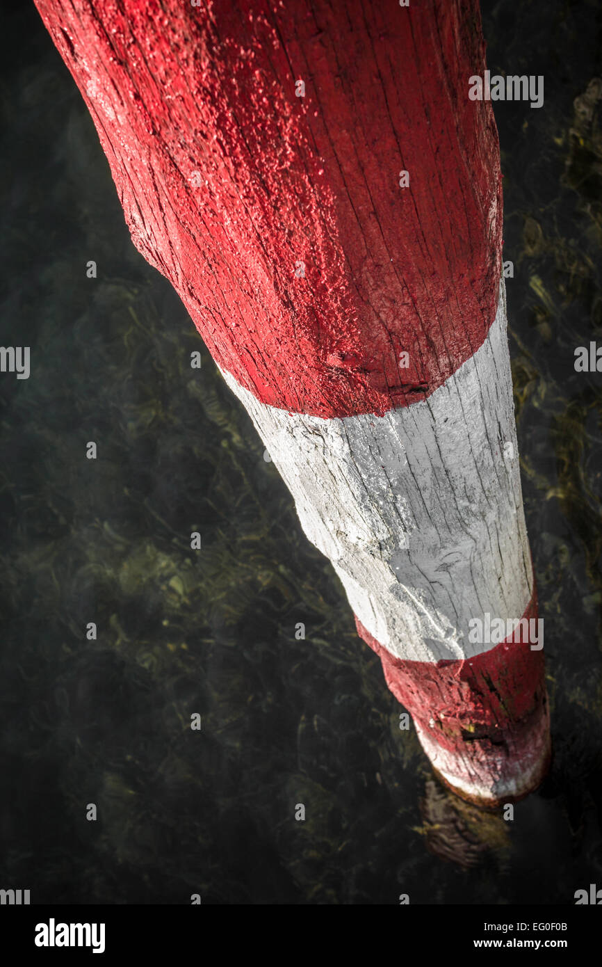 A wooden pole red and white, on the lakeside Stock Photo - Alamy