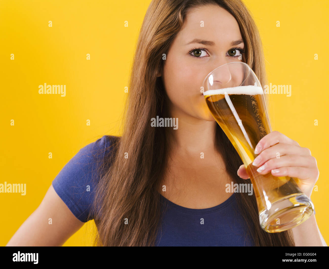 Photo of a beautiful young brunette woman drinking beer from a tall ...