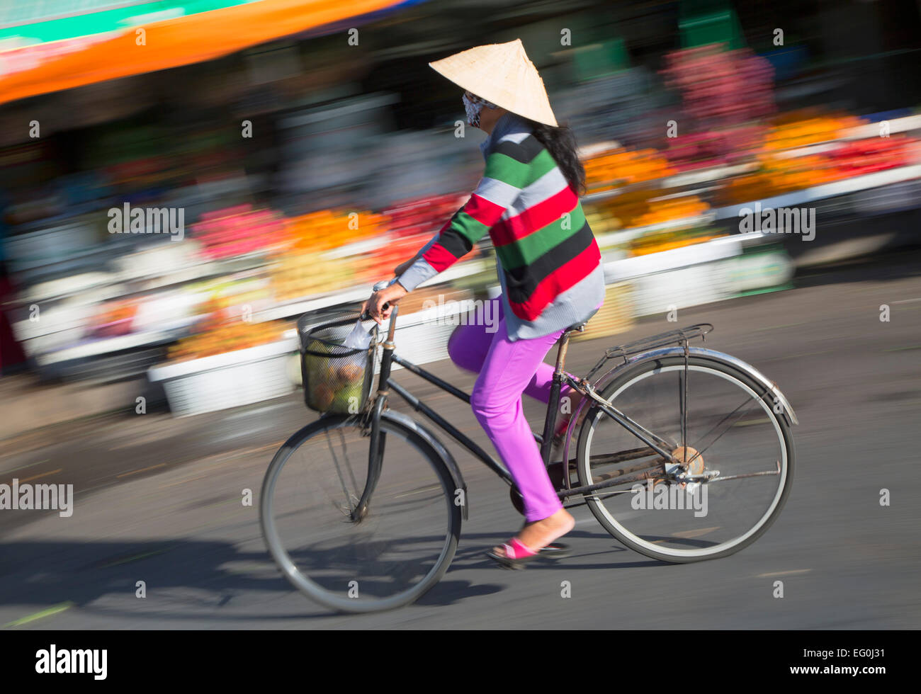 Woman cycling past market, Ben Tre, Mekong Delta, Vietnam Stock Photo ...