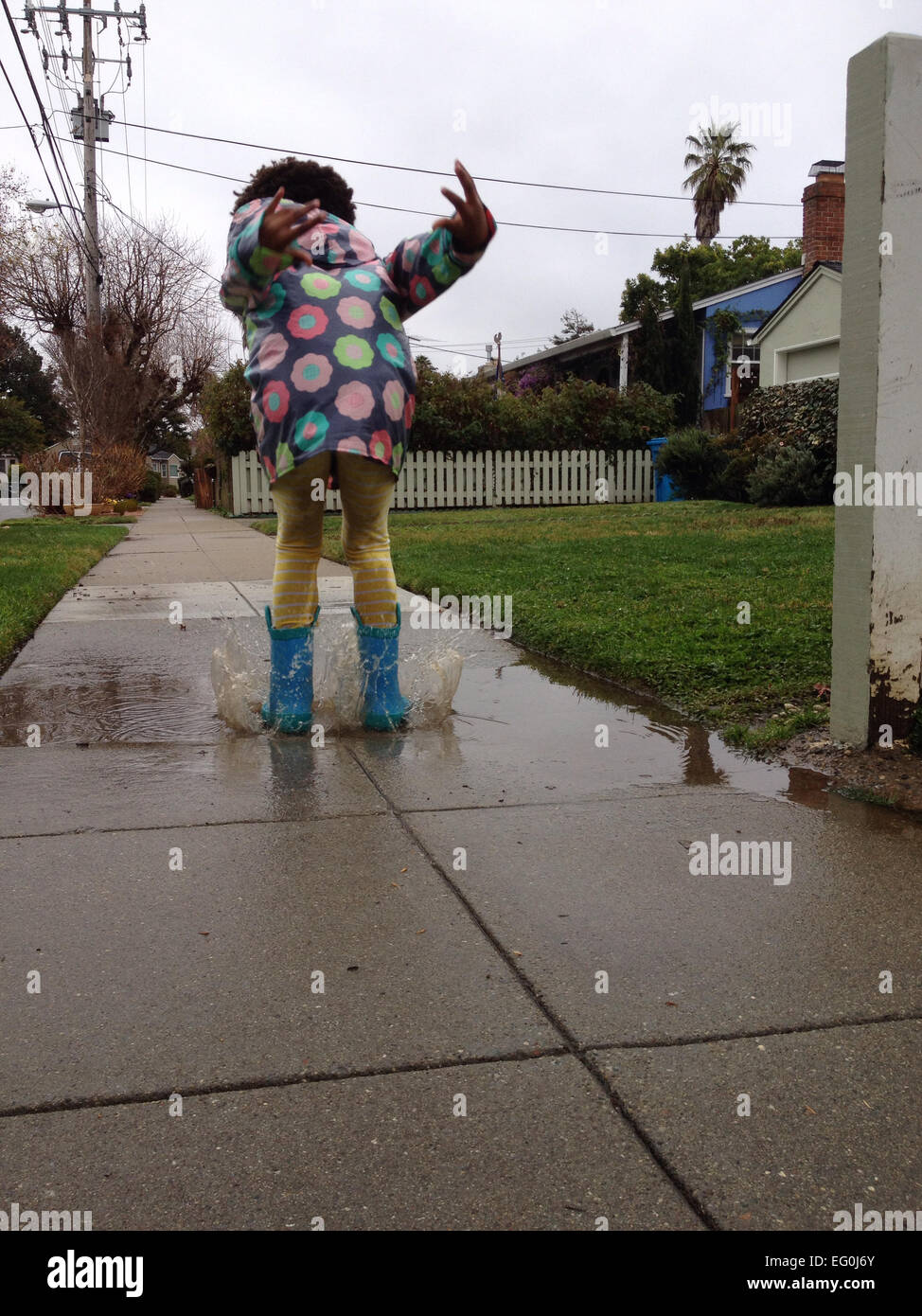 Girl jumping into puddle Stock Photo - Alamy