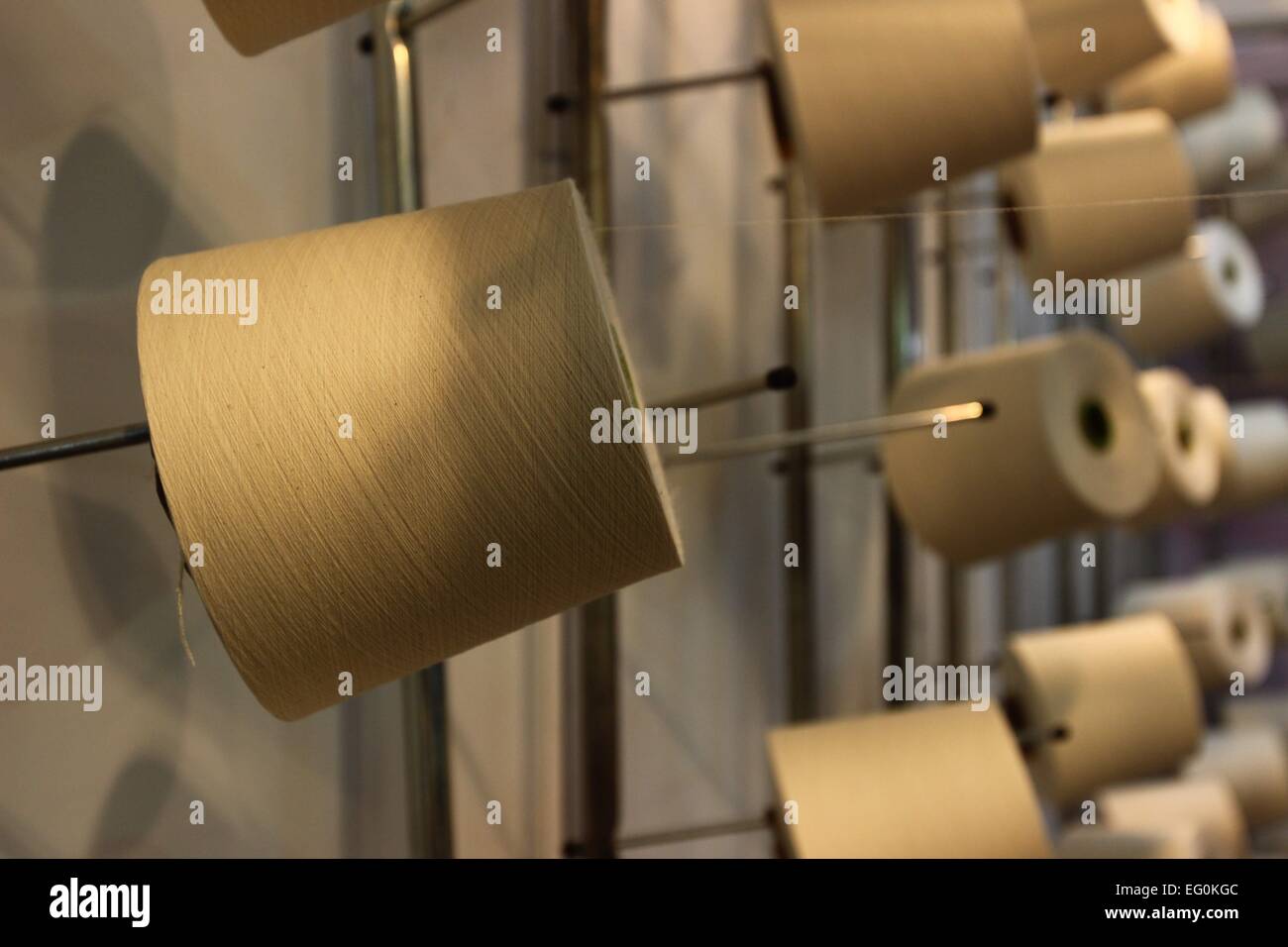 Dhaka 09 February 2015. Group of bobbin thread cones on a warping ...