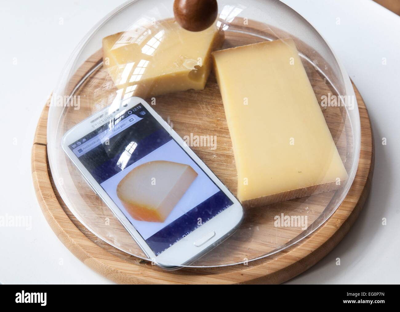 Is this virtual or real? A smartphone showing a photo of cheese, next ...