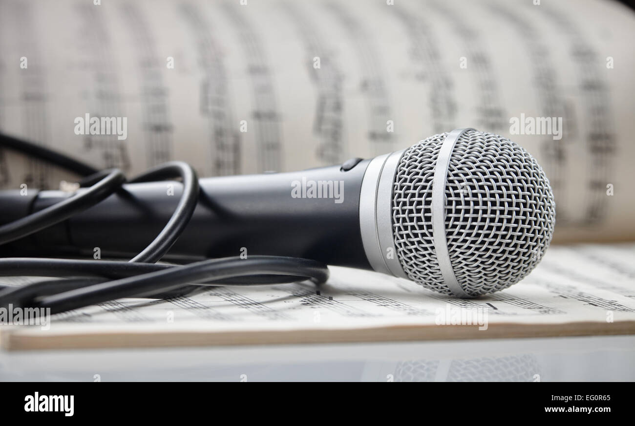Microphone with cable lying on sheet music Stock Photo - Alamy