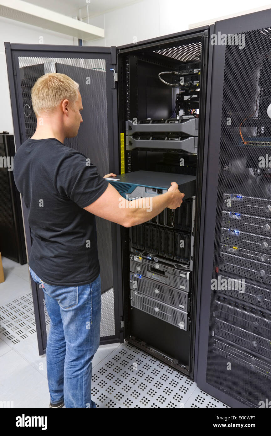 It engineer / consultant install / inserts a router / switch in a rack ...