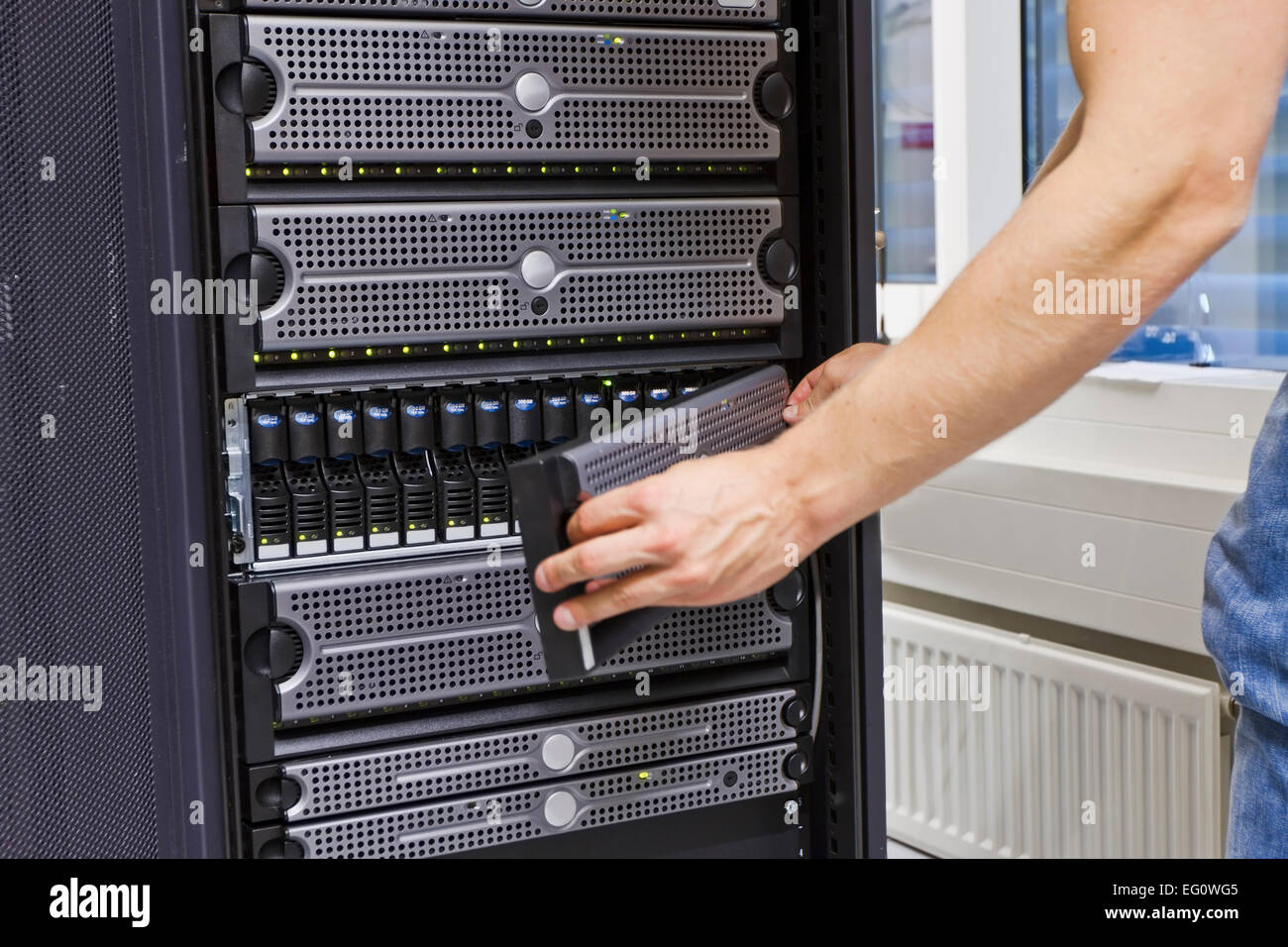 It engineer / consultant working in a data center. Holding a disk ...