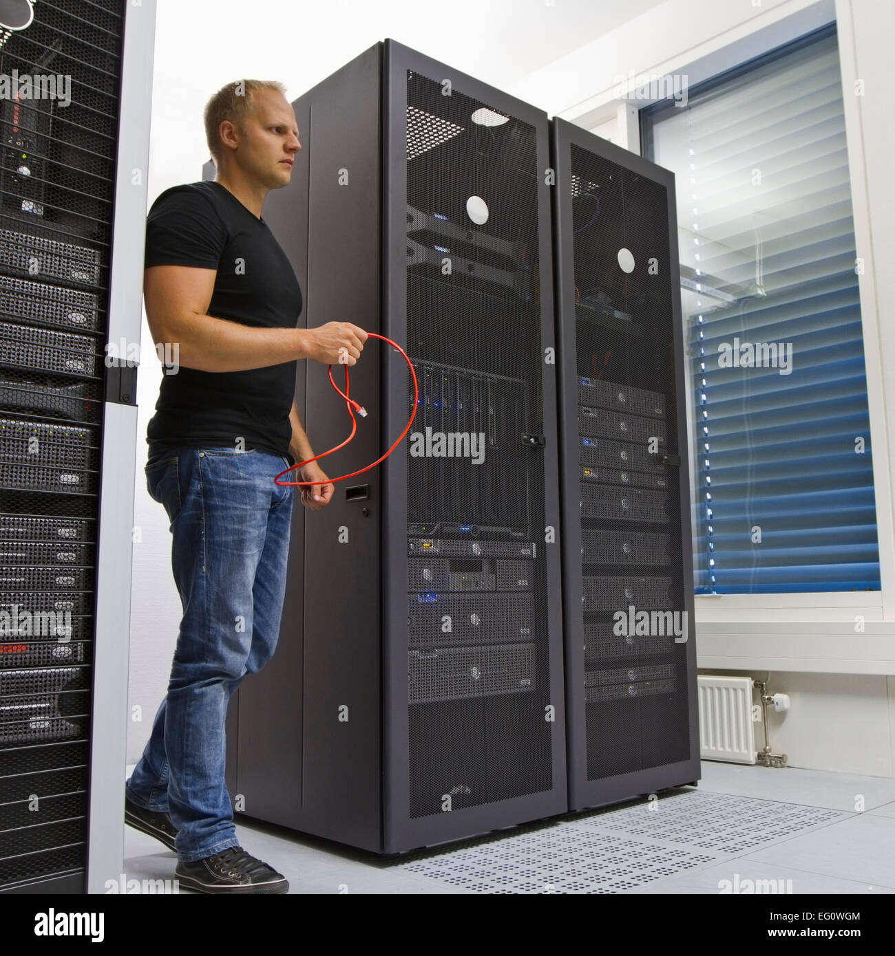 It engineer / consultant working in a data center. Holding a ethernet ...