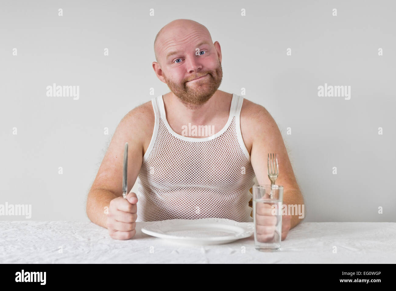 Hungry and happy man with no food on his plate. Perphas on a diet Stock ...