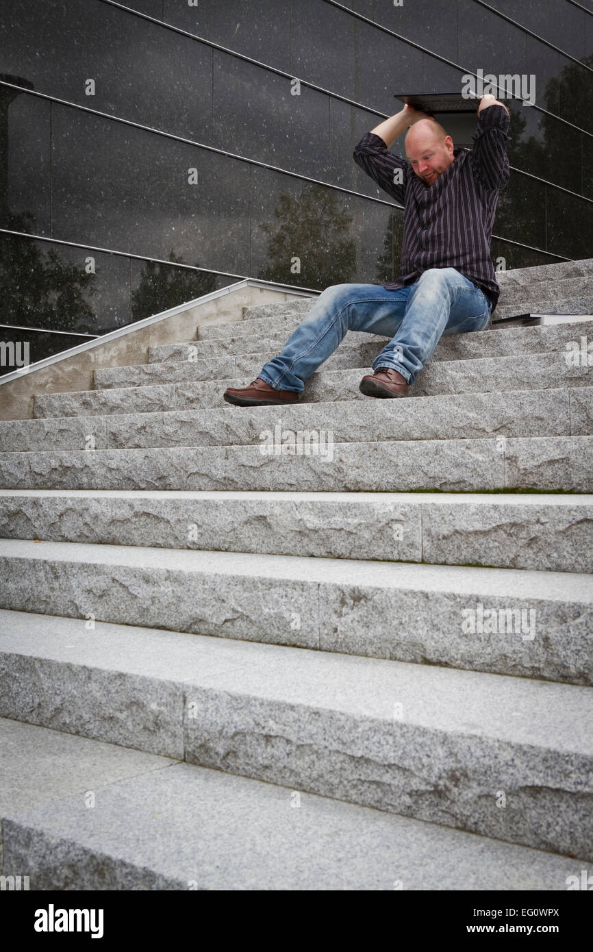 A angry man bites his computer / laptop in the stairs Stock Photo - Alamy