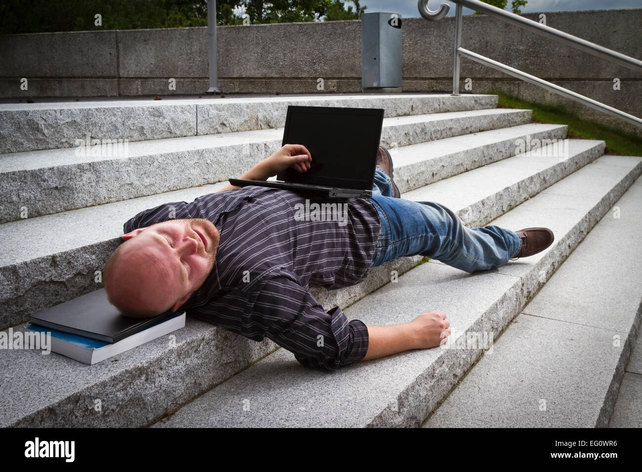 A sleeping / resting / exhausted man working with his computer / laptop ...