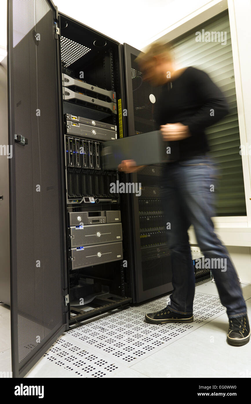 A fast working IT engineer / technician installing a server in a rack ...