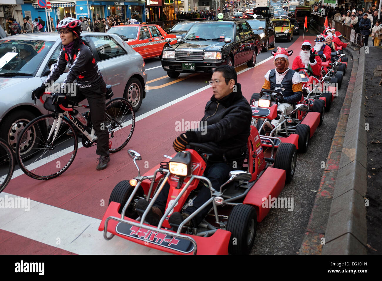 A parade of go-cart drivers in Christmas costumes sit in a traffic jam ...