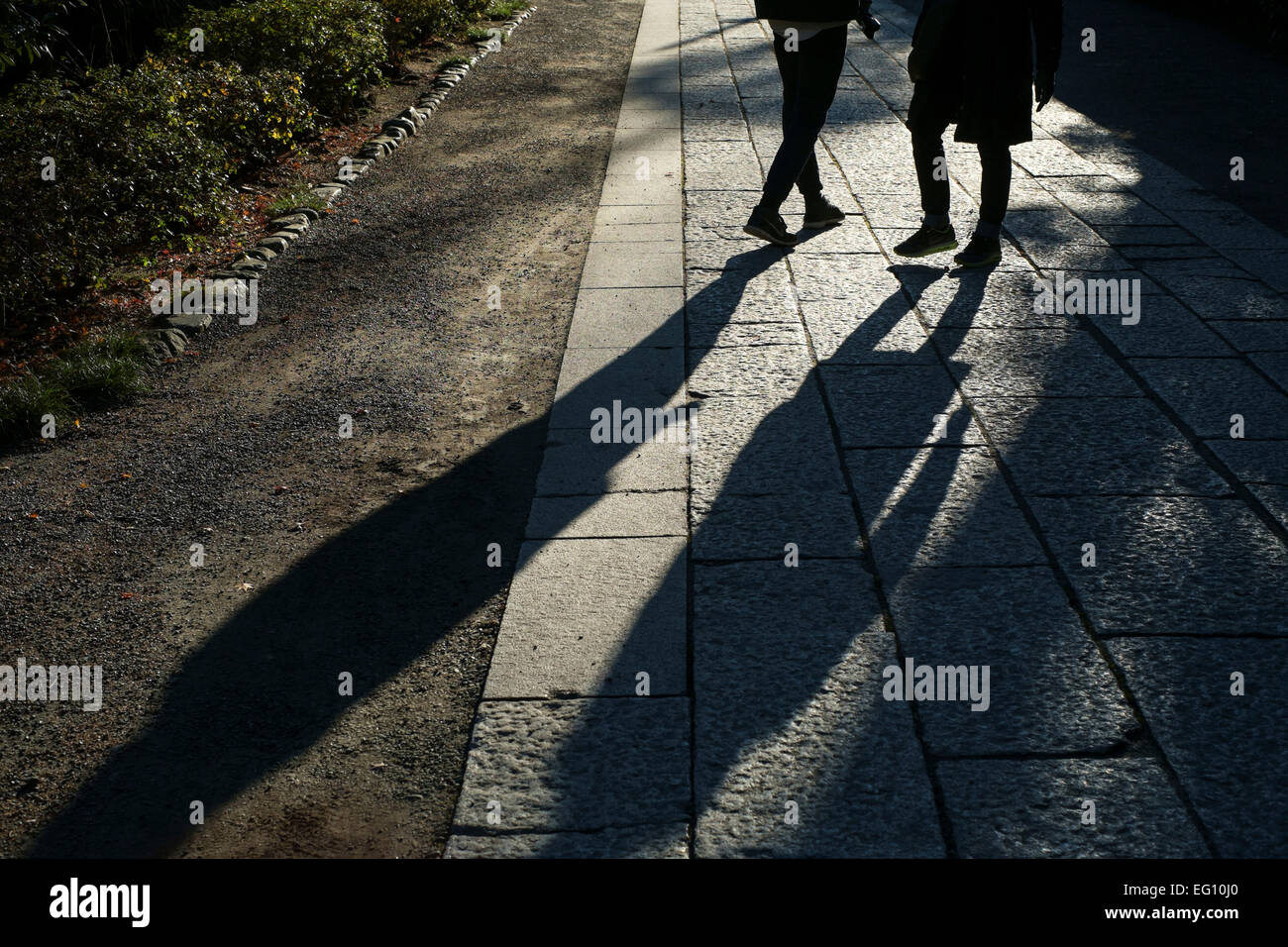 Legs and shadows silhouetted on a path. Kamakura, Japan Stock Photo - Alamy