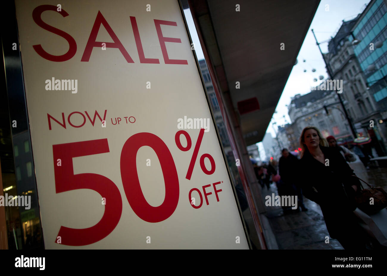 UNITED KINGDOM, London : Shoppers walk past sales signs on Oxford ...