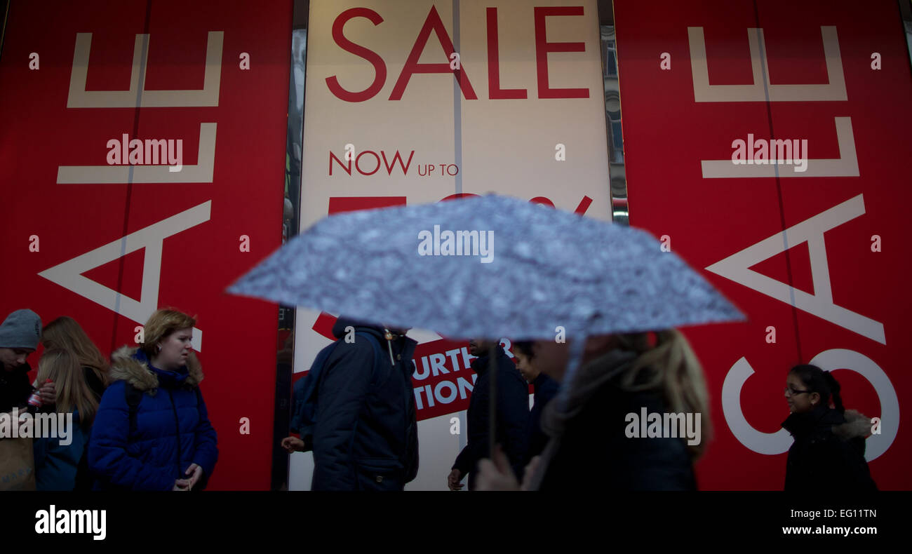 UNITED KINGDOM, London : Shoppers walk past sales signs on Oxford ...